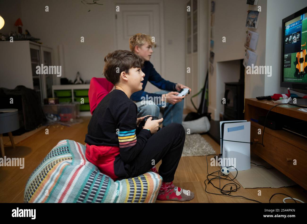 Teenage brothers playing on a Nintendo gaming console at their ...