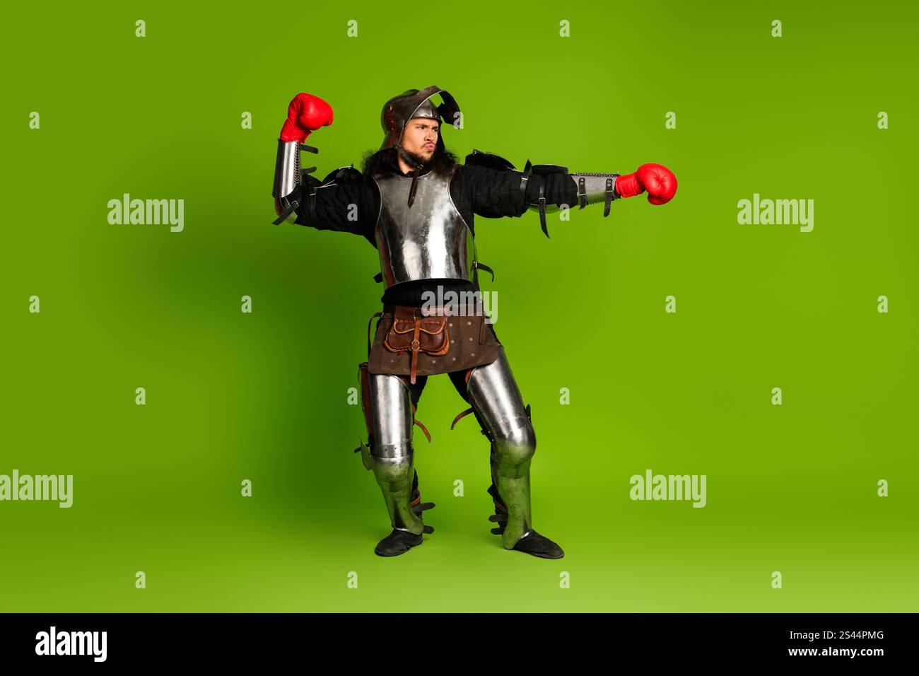 Young man dressed as a knight wearing boxing gloves and performing a ...