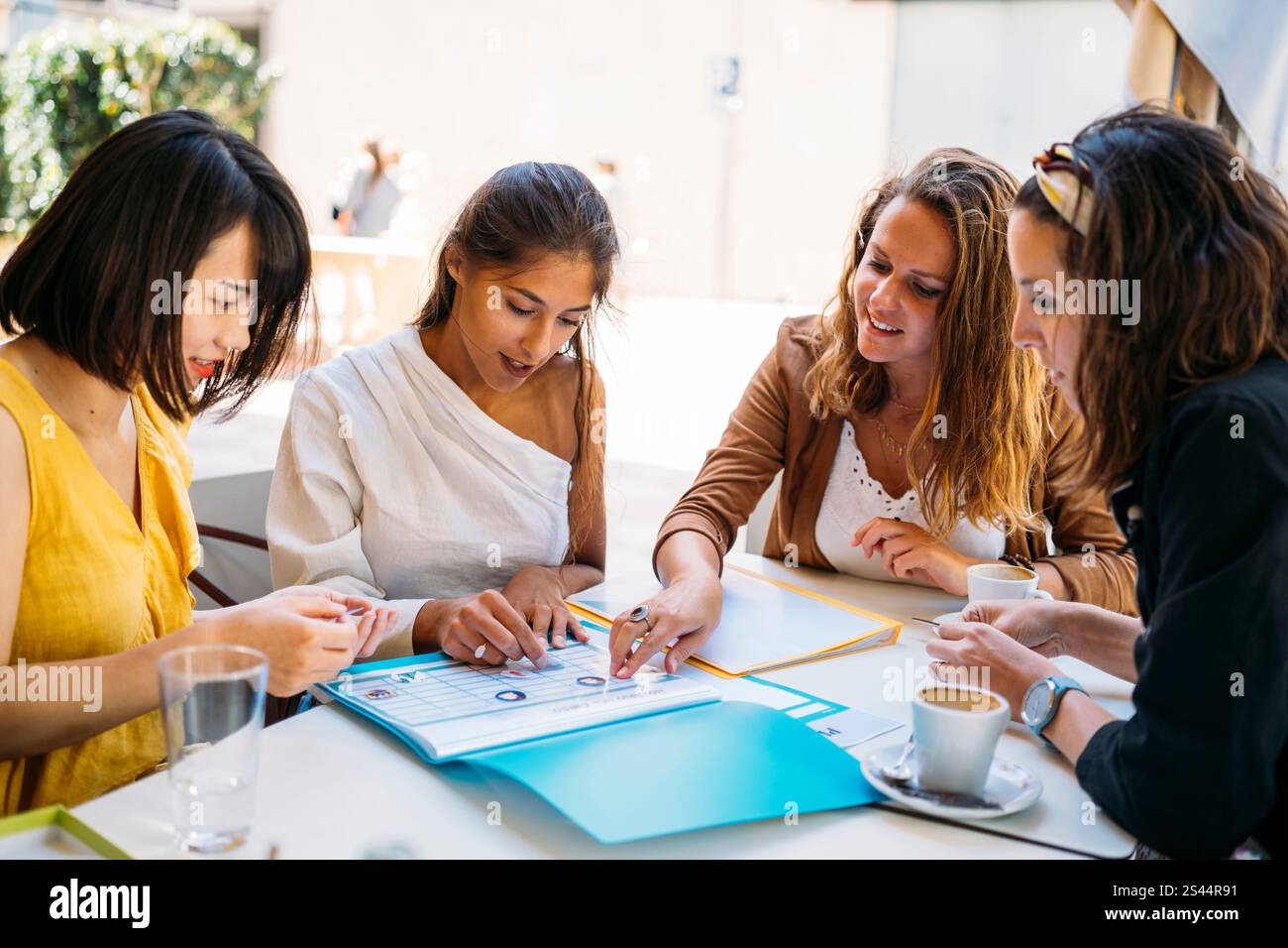 University exchange students planning and studying together at a cafe ...
