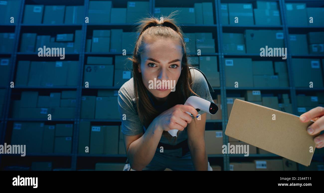 Tired Female Warehouse Employee Looking at Camera, Scanning Cardboard ...