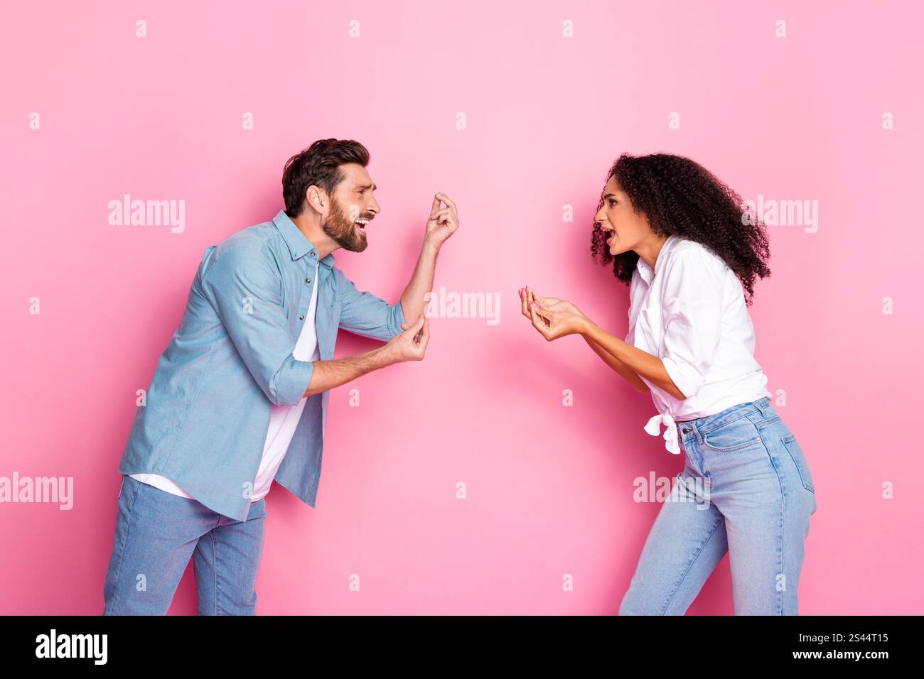Young couple passionately arguing against pink backdrop representing ...