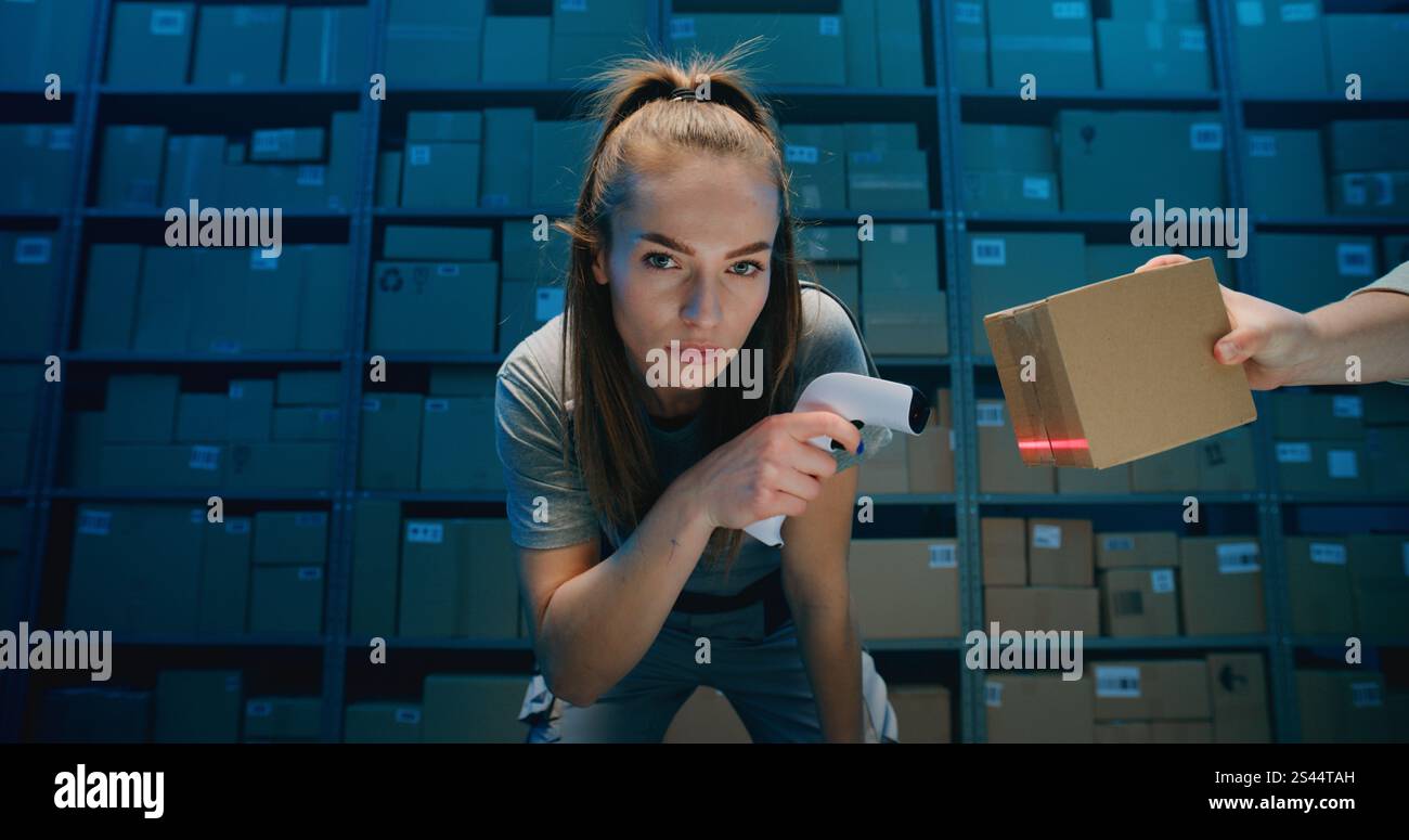 Tired Female Warehouse Employee Looking at Camera, Scanning Cardboard ...