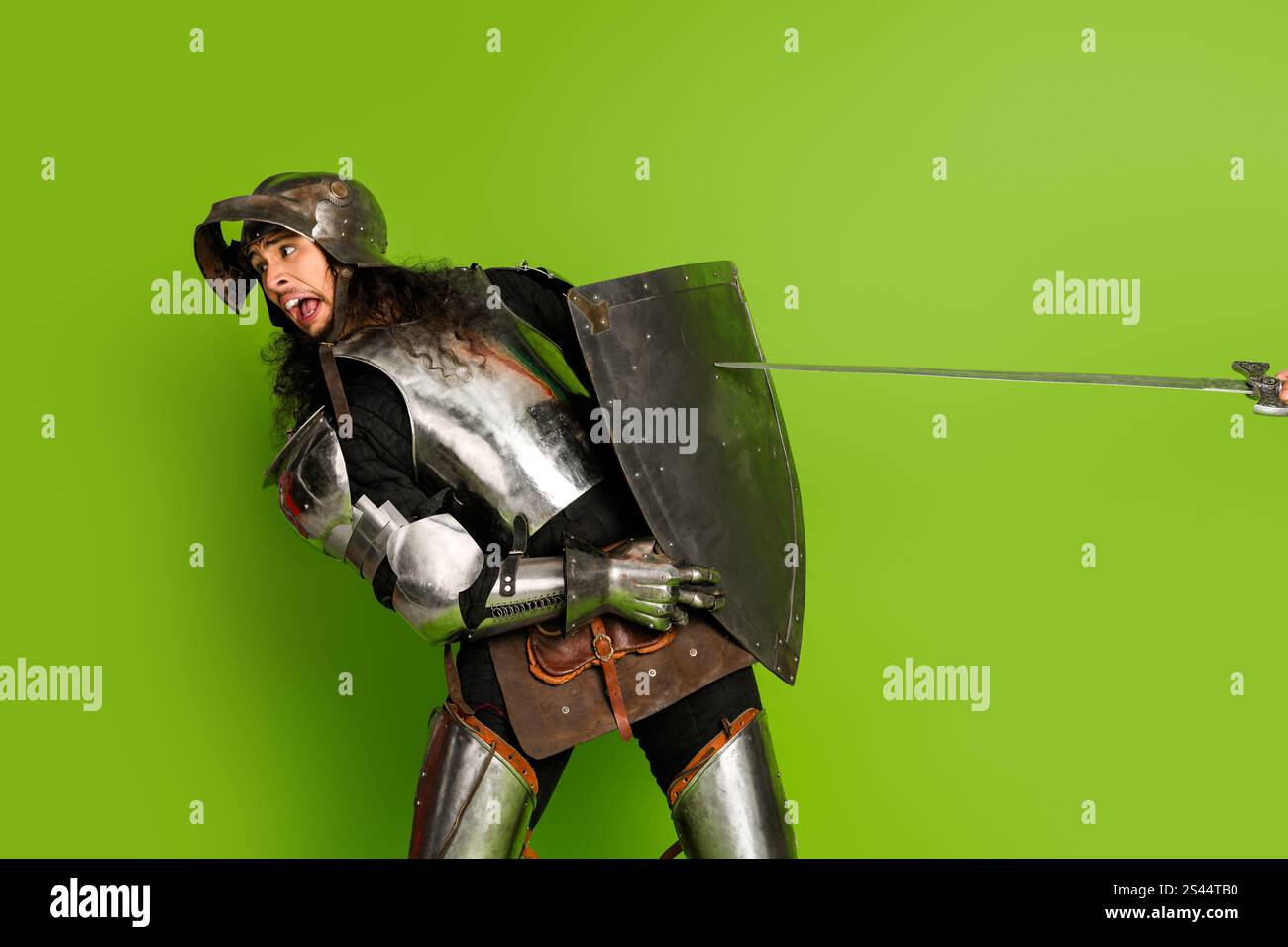 Funny medieval knight in armor on green background holding shield and ...