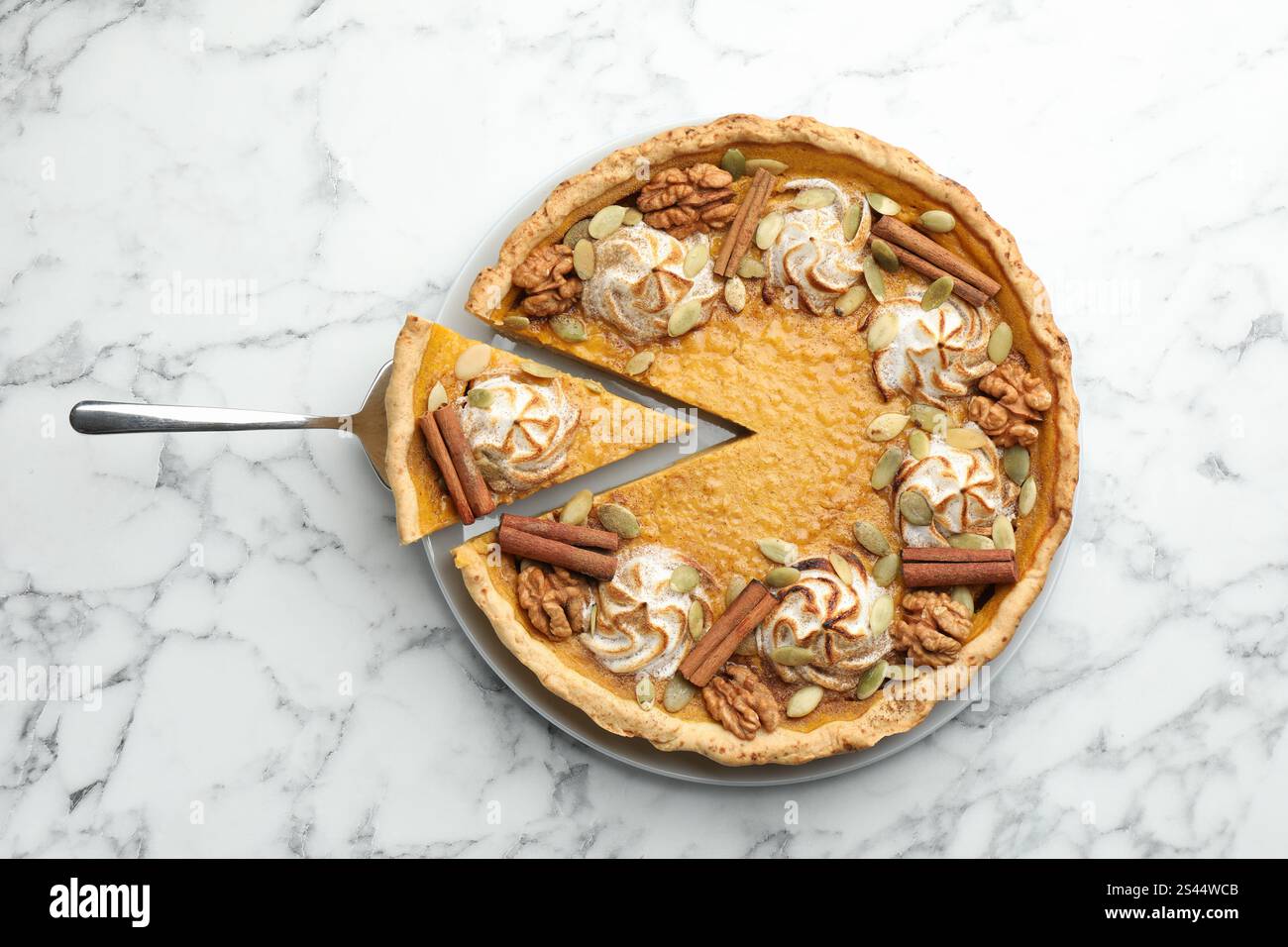 Tasty homemade pumpkin pie with server on white marble table, top view ...