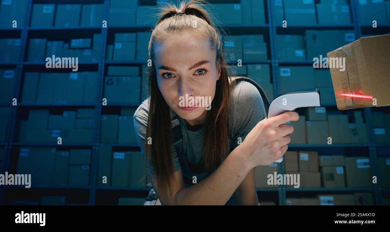 Exhausted Female Warehouse Worker Looking at Camera, Scanning Parcels ...