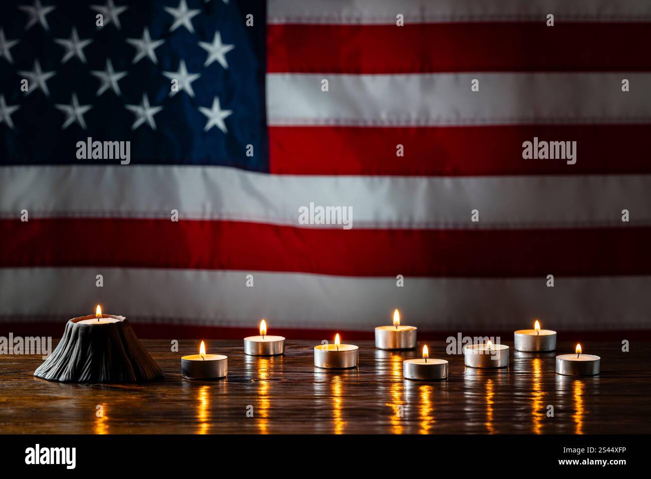 Burning candles on table for honoring and mourning with American flag ...