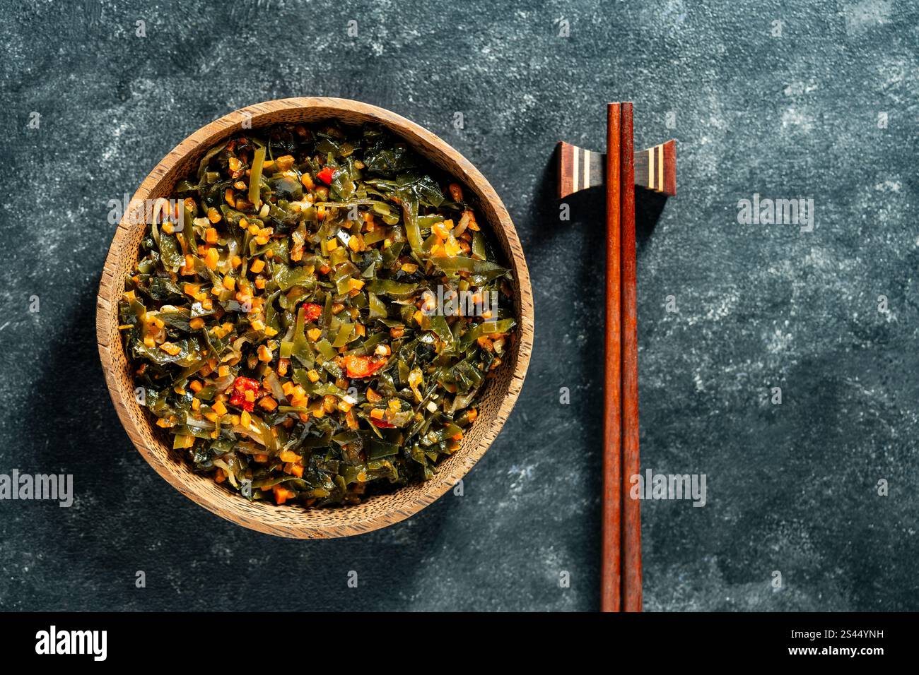 Healthy and fresh seaweed salad with carrot and pepper in wooden plate ...