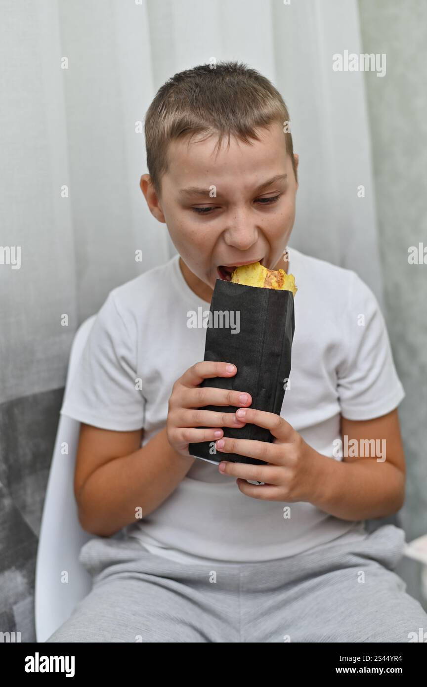 boy eats delicious shawarma with an appetite Stock Photo - Alamy