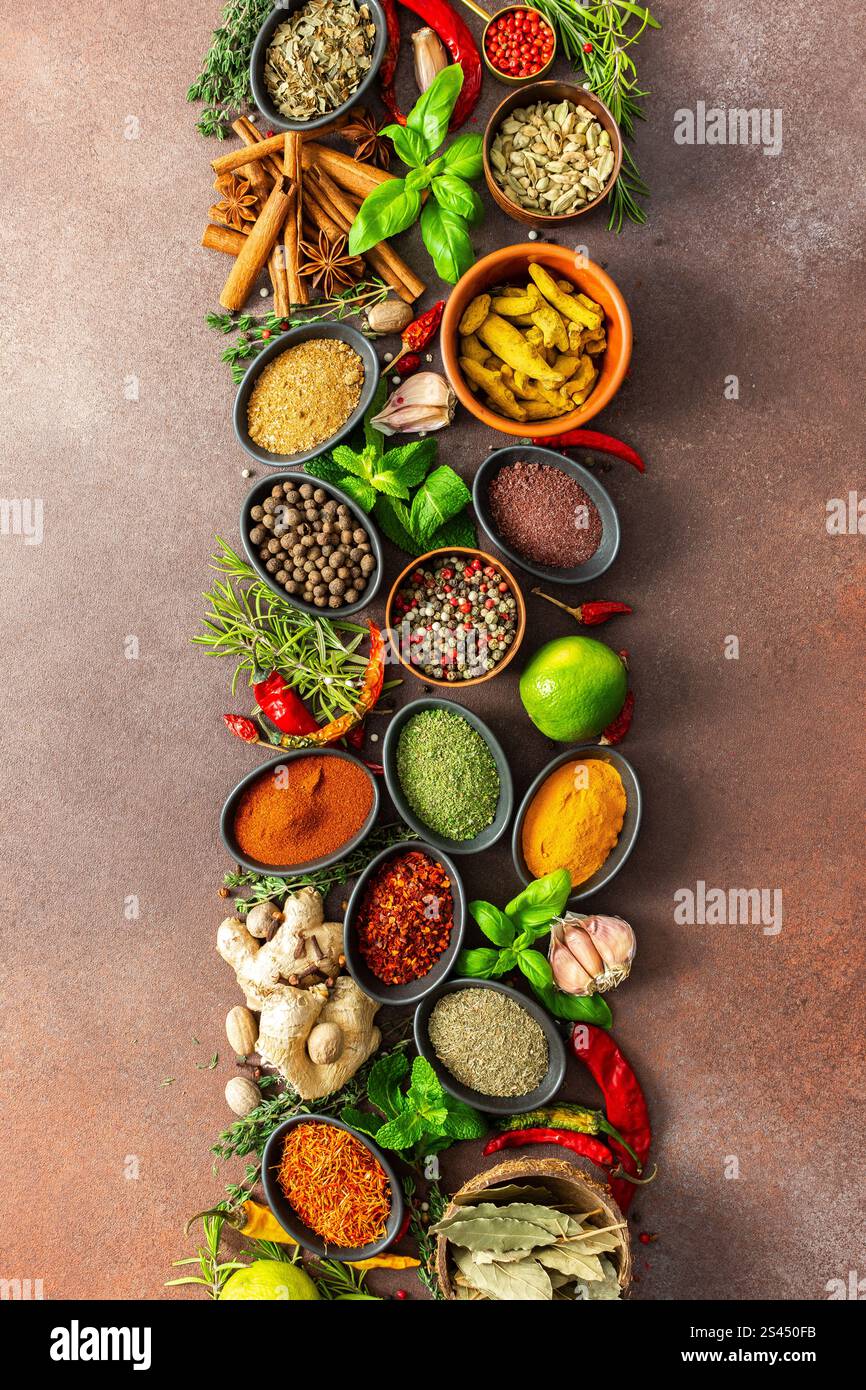 An artistic display of fragrant herbs and spices, scattered on a brown ...