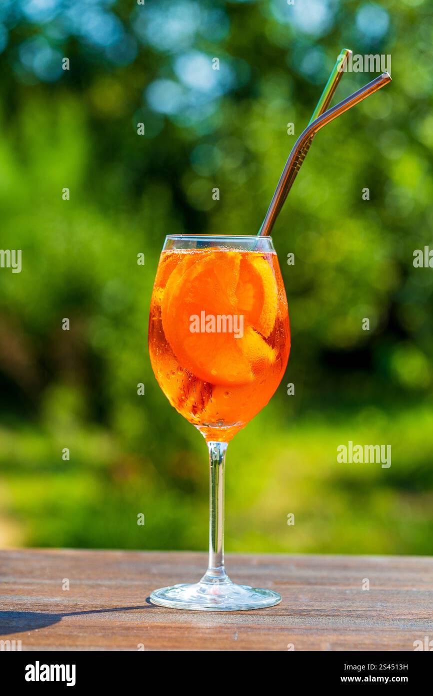 Aperol spritz cocktail in wine glass on a nature background. Classic ...