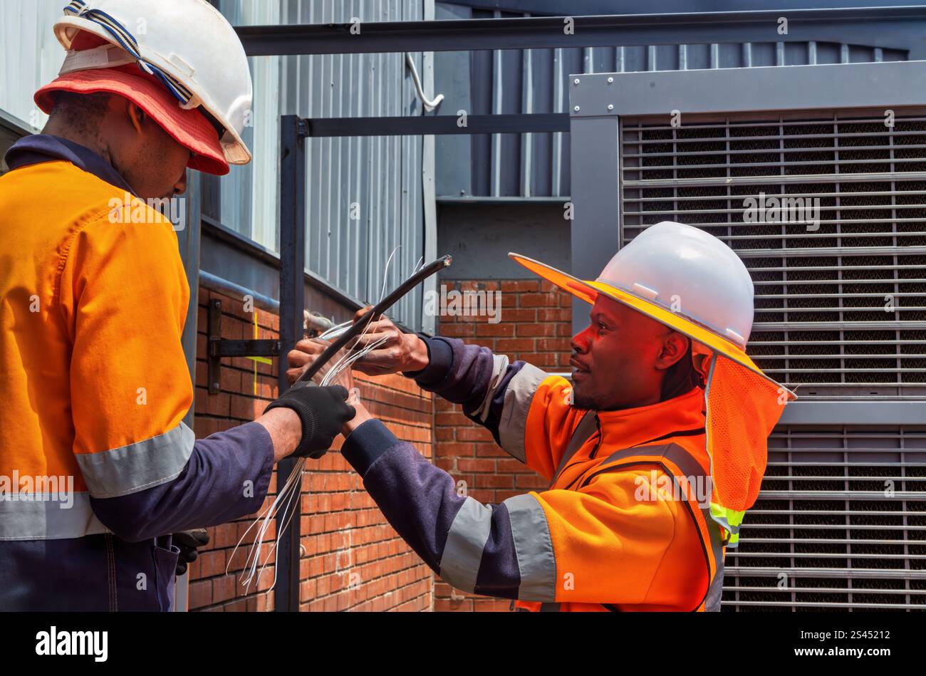 african american workers colleagues, repairing hvac unit, with orange ...