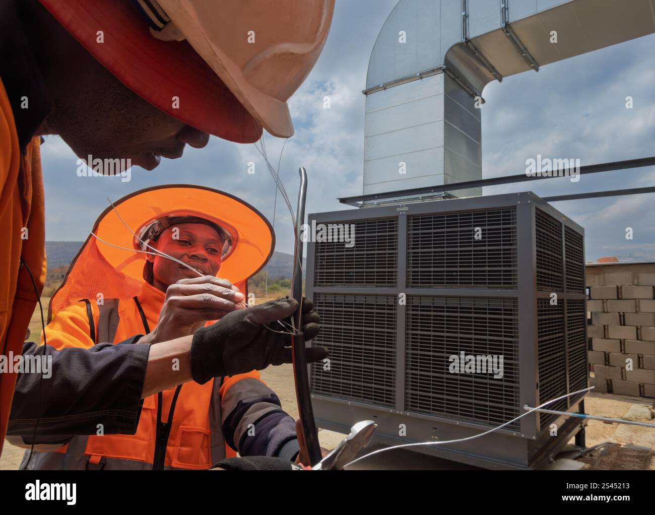 african american workers colleagues, repairing hvac unit, with orange ...