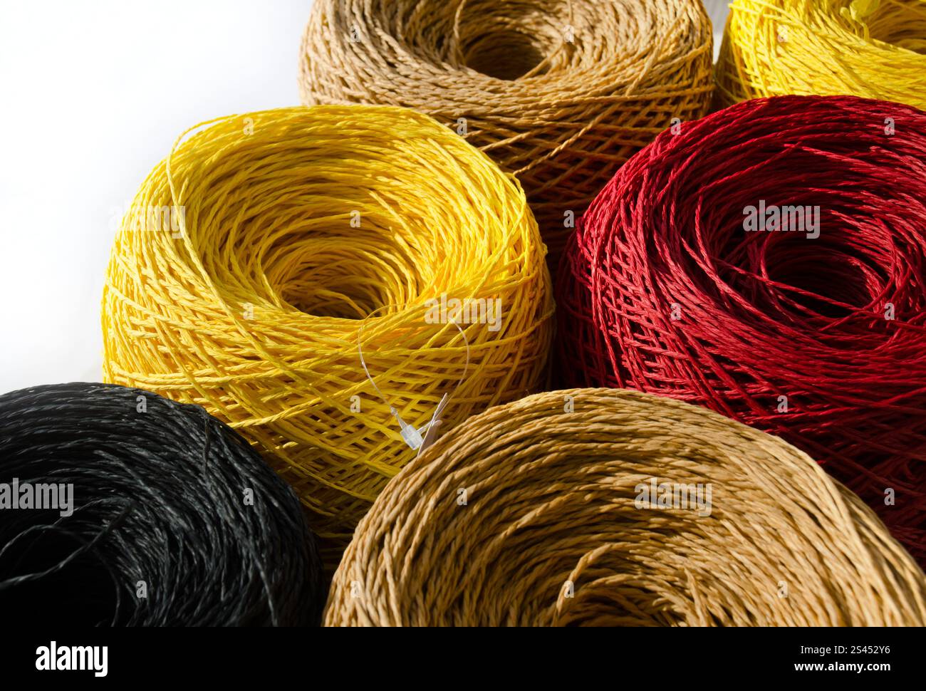 Raffia rolls close-up. Skeins of multi-colored raffia on a white ...