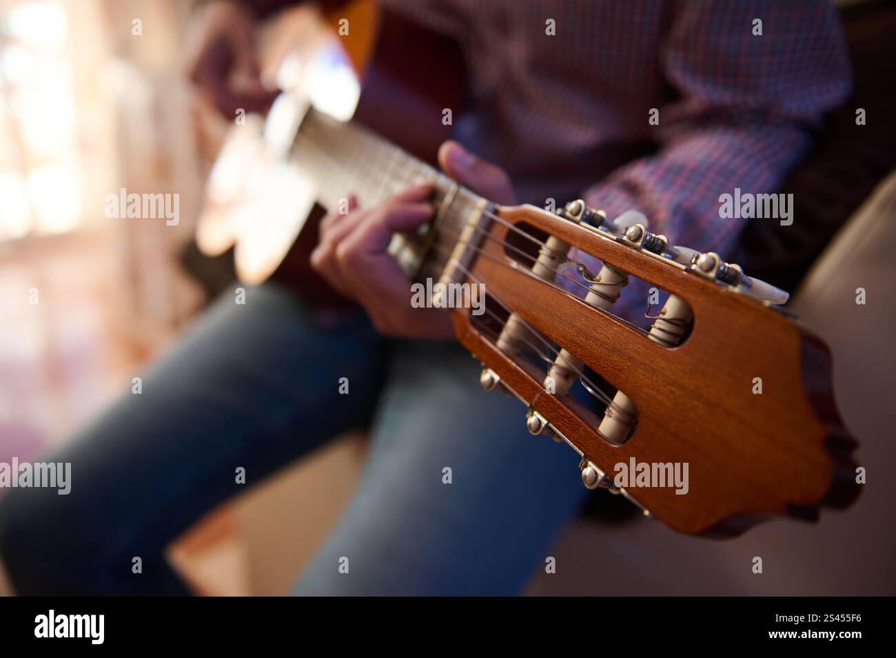 A detailed view of an acoustic guitar being played by a person in ...
