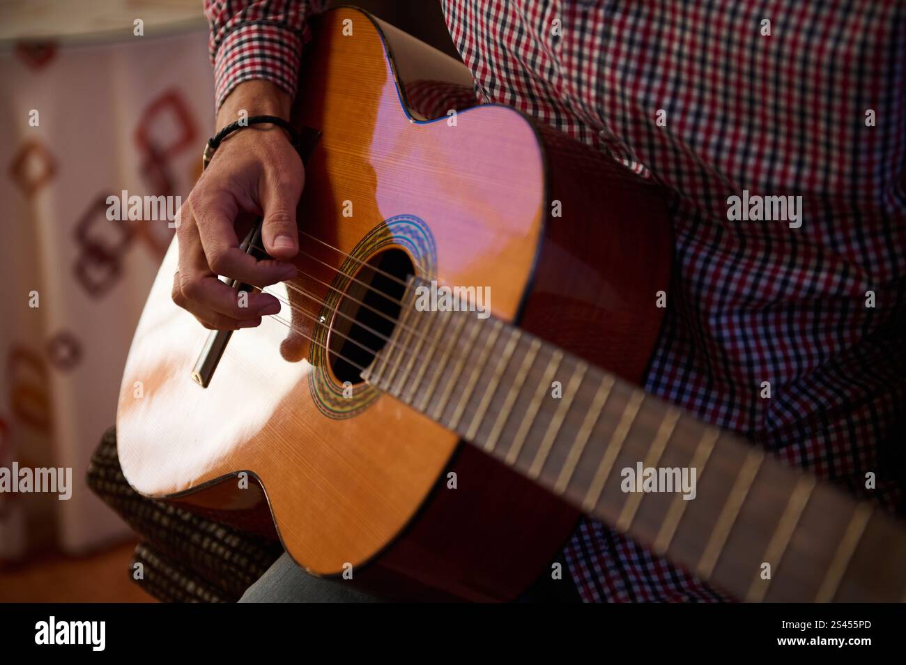 A close-up view of a musician's hands playing a guitar. This image ...