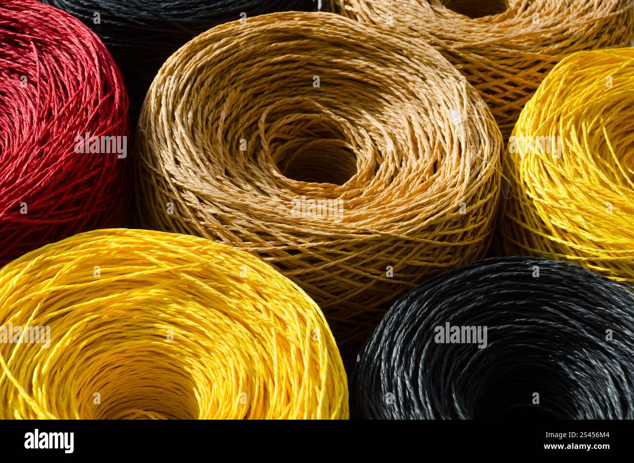 Rolls of colored raffia close-up. Skeins of multi-colored raffia. Eco ...