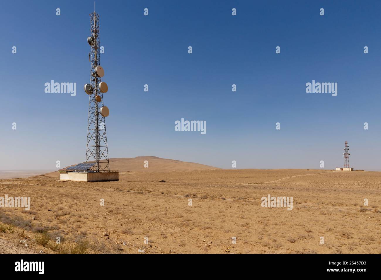 Two communication towers stand in a dry, barren landscape in Kunduz ...