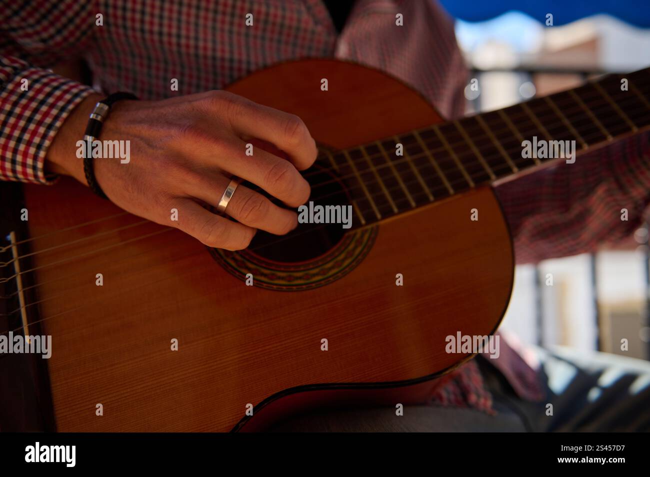 A person strumming strings on an acoustic guitar with emphasis on hand ...