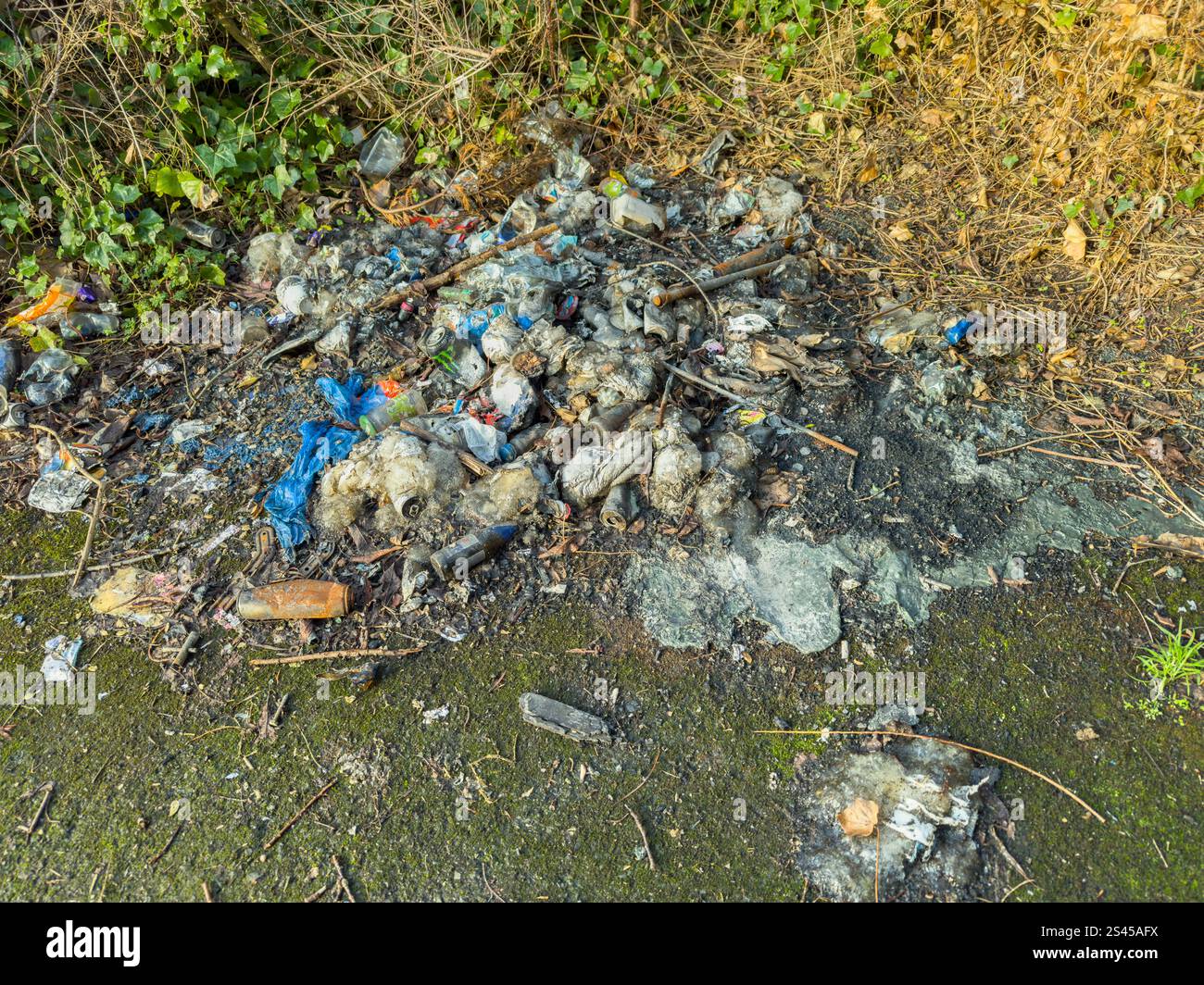 Pile of burnt and unburnt trash rubbish with plastic debris and ash on ...