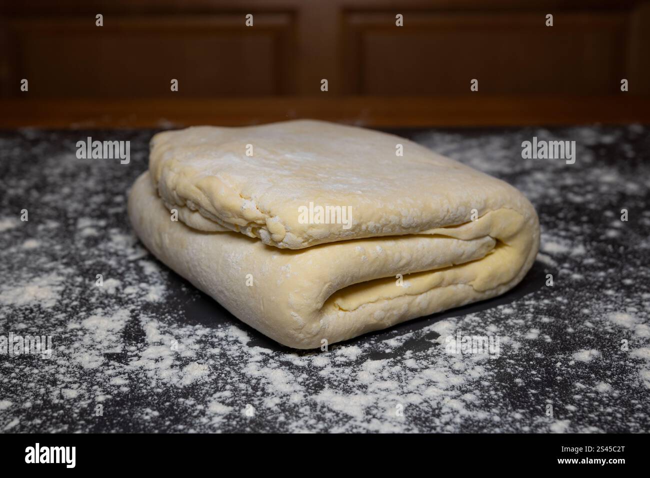 Homemade, folded, square, pastry dough with flour dusting on a kitchen ...