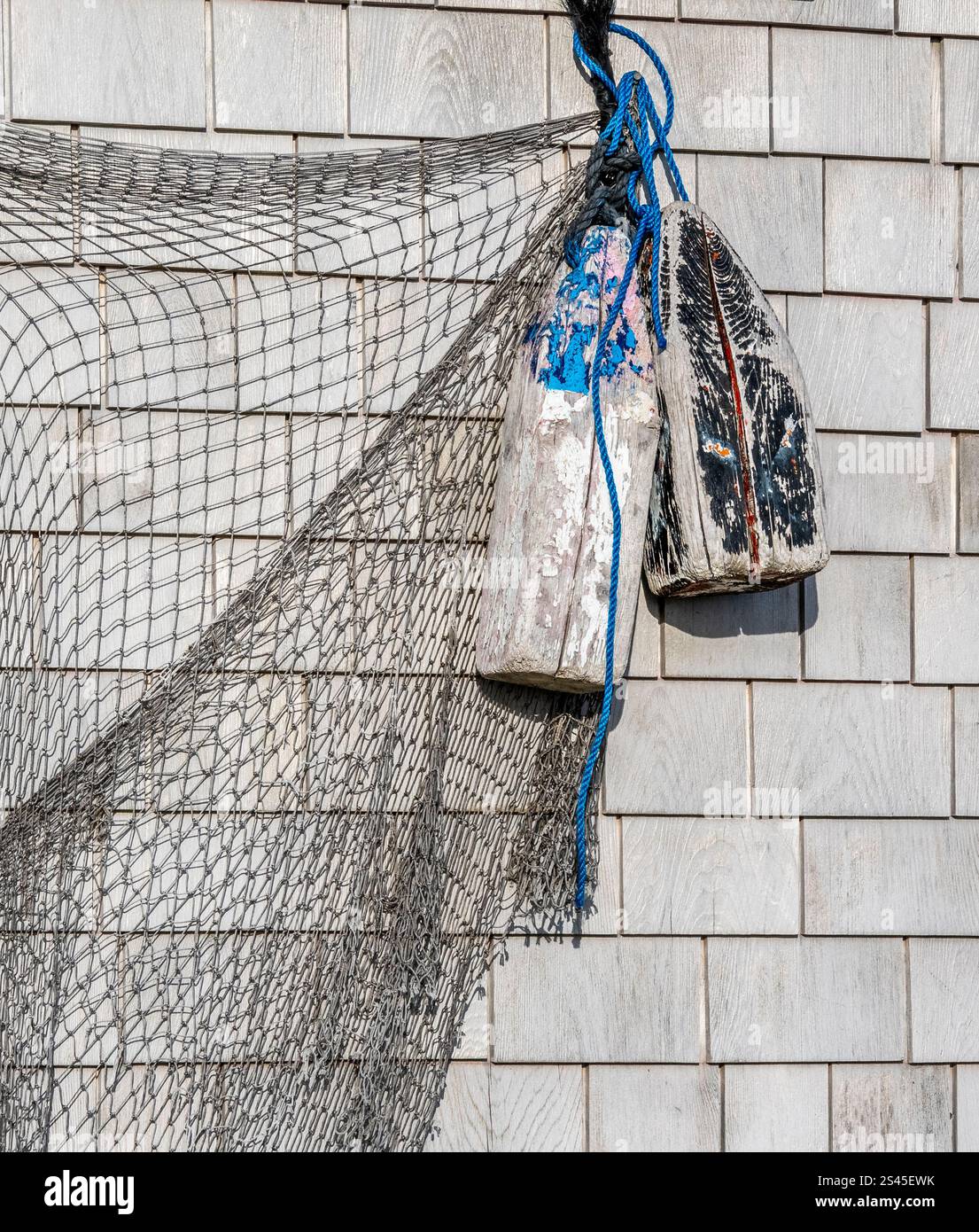 Fishing nets and lobster trap bouys hanging on a shake single wall in ...