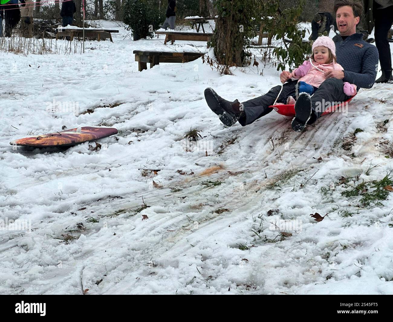 Nathan Lee and his 4-year-old daughter Lou sled down a hill in their ...