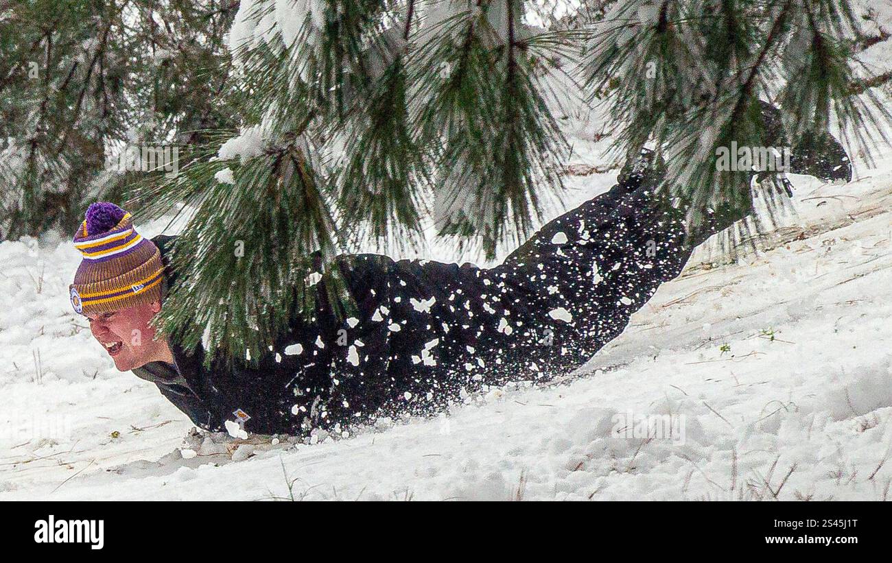 Drew McDonald slides down a hill as snow falls Friday, Jan. 10, 2025 ...