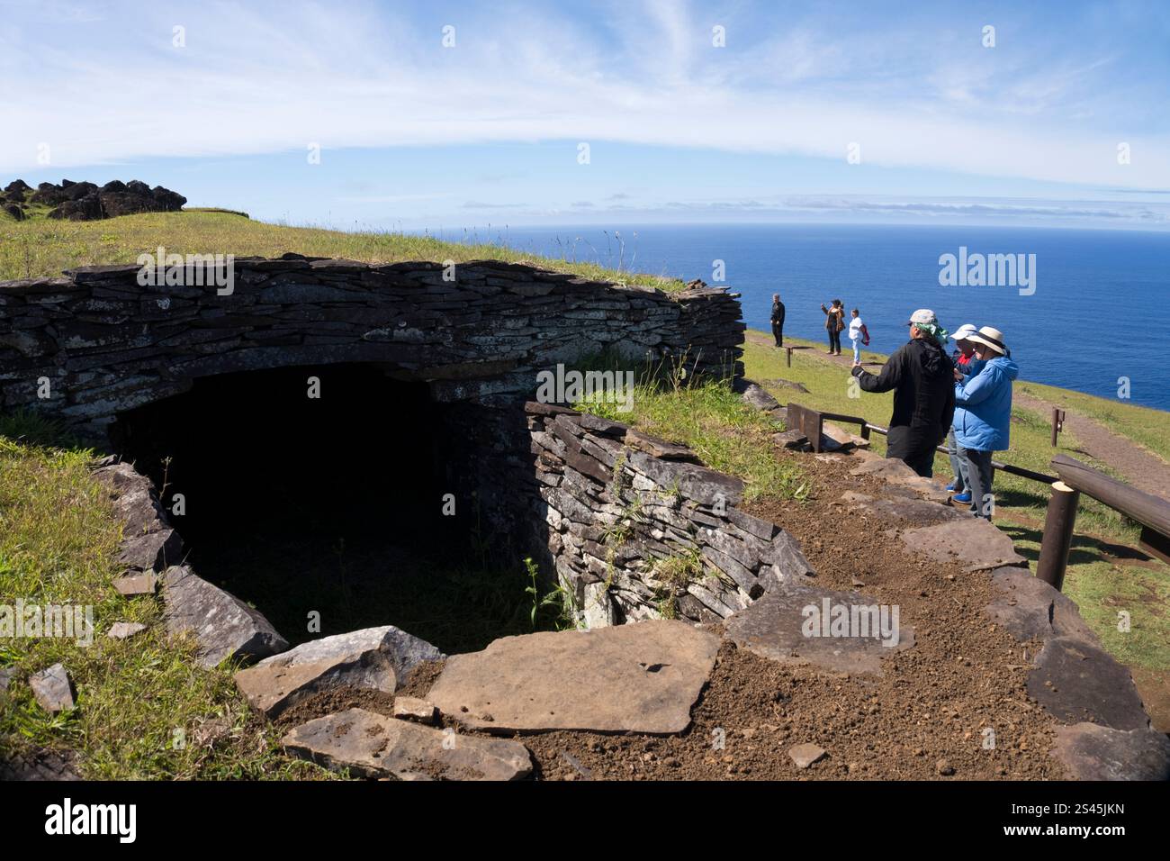 A tour guide explains an open building (for viewing inside) at Orongo ...