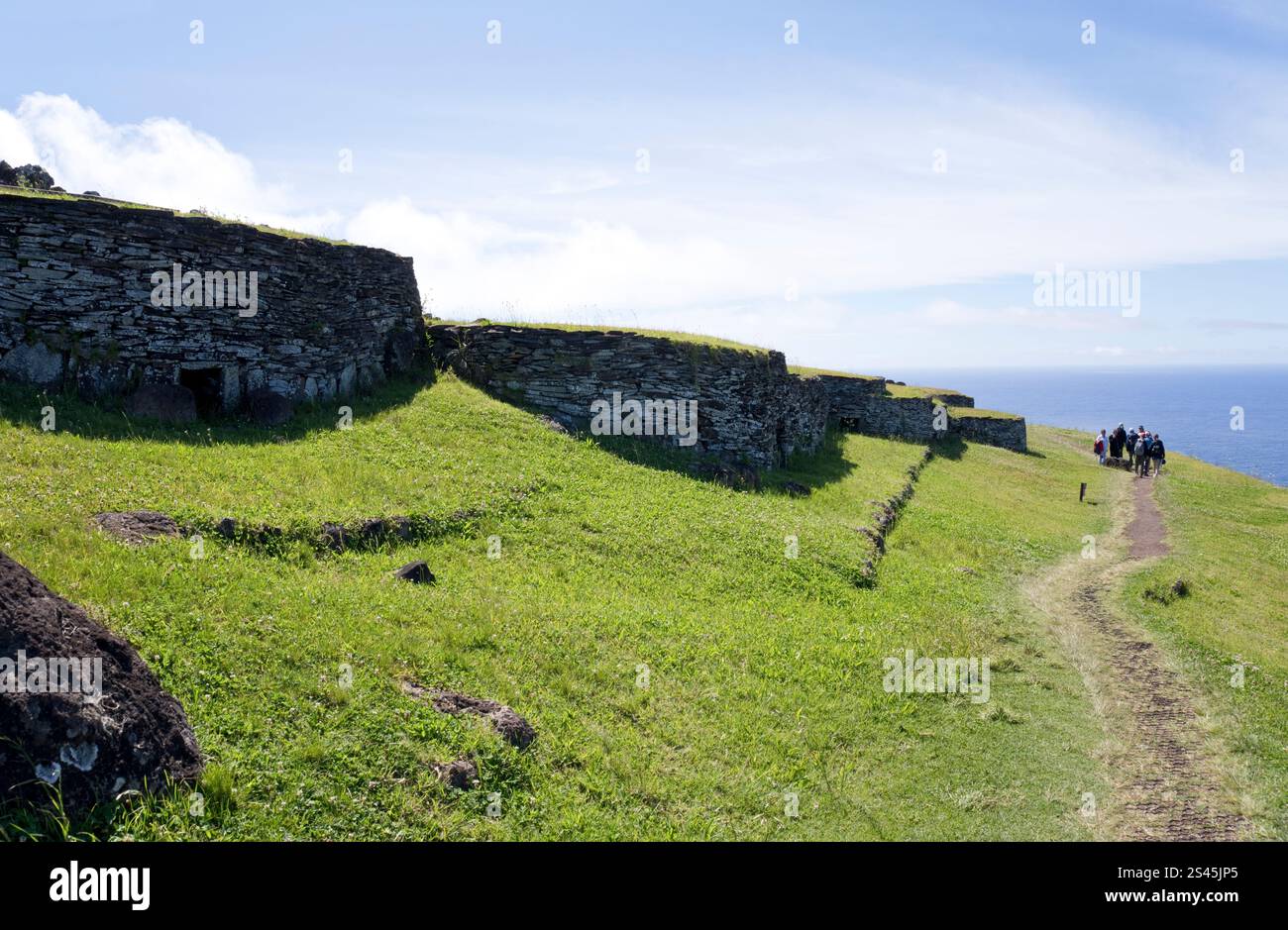 Tour group visits Orongo, sod-covered, windowless, buildings that were ...