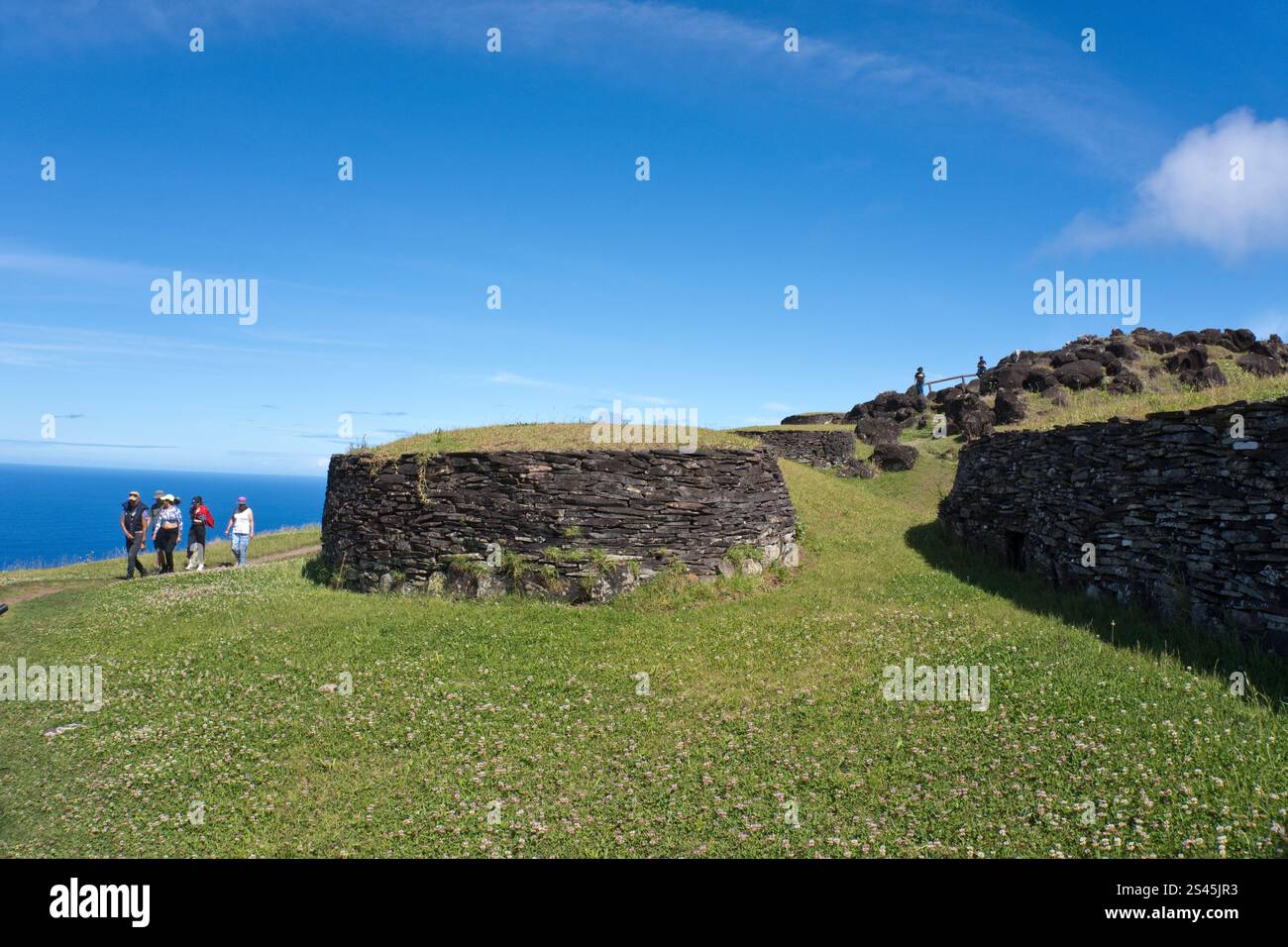 Tour group visits Orongo, sod-covered, windowless, buildings that were ...