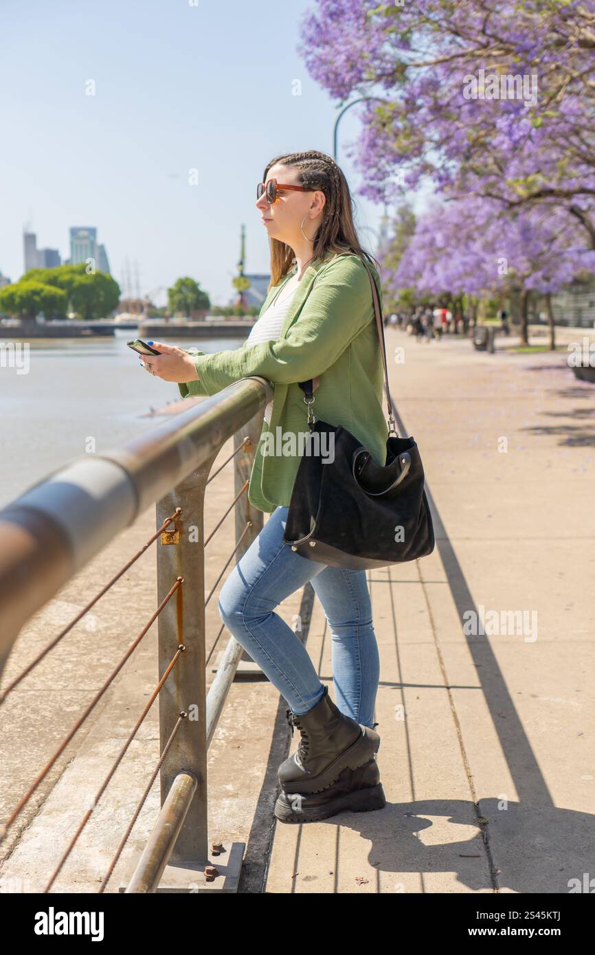 Woman checking smartphone she stands hi-res stock photography and ...