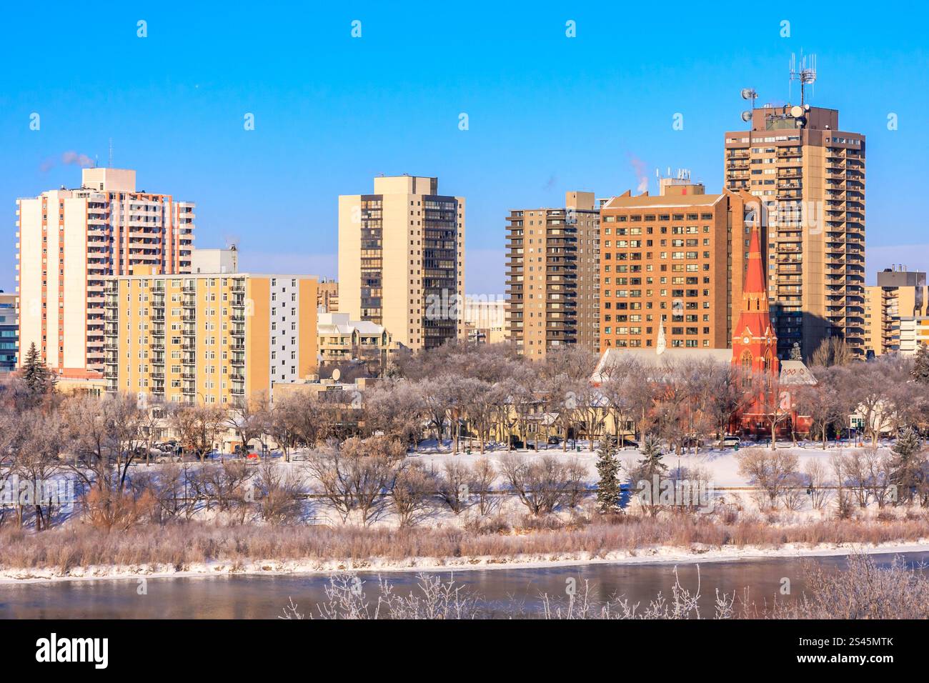 A city skyline with a red brick church in the middle. The sky is clear ...