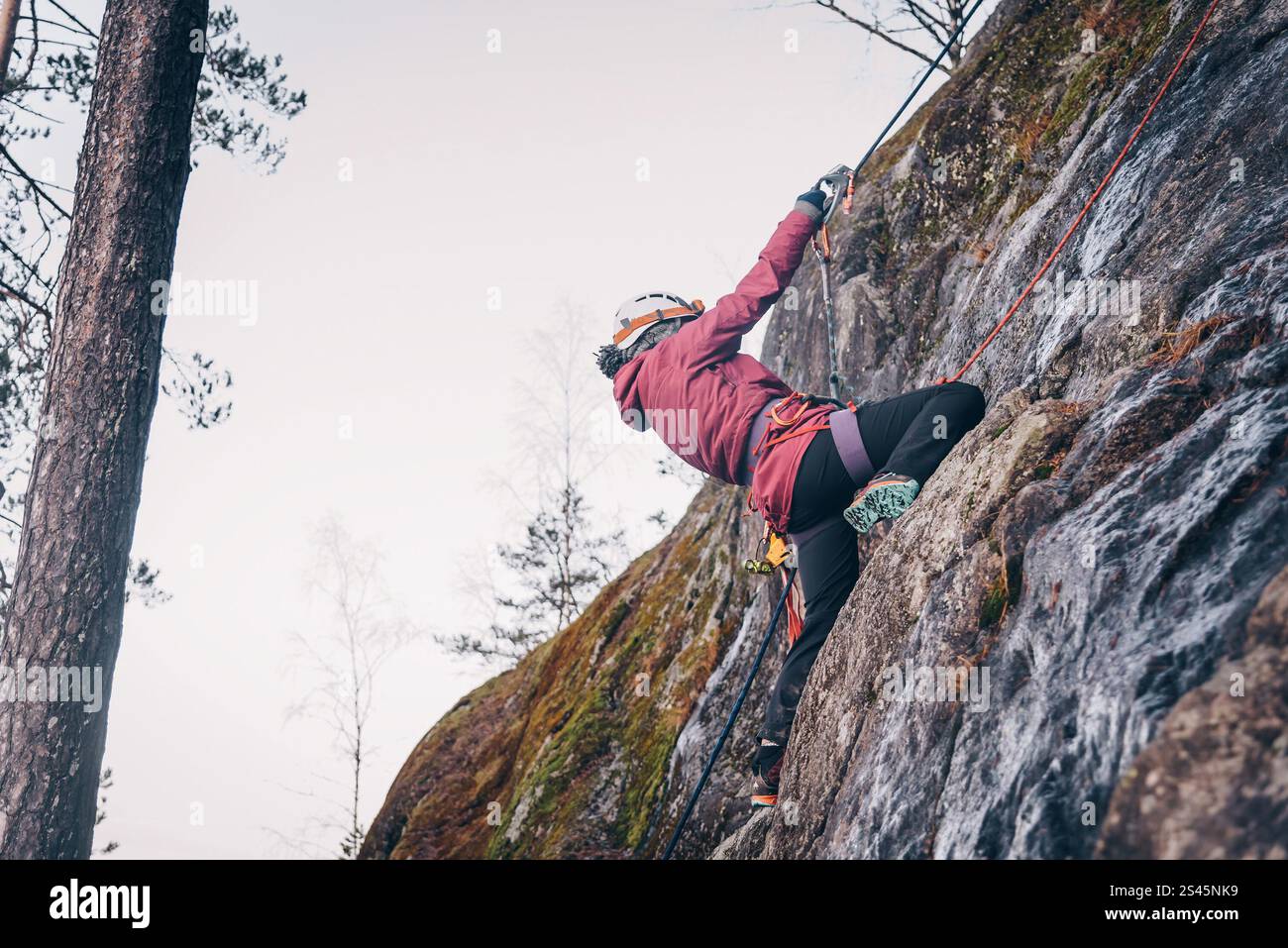 Rock climber climbing high rock wall extreme sports outside, alpinism ...