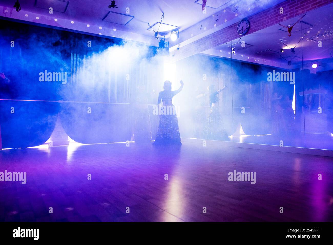 Woman in long dress dancing in colored smoke, dancer in studio showing ...