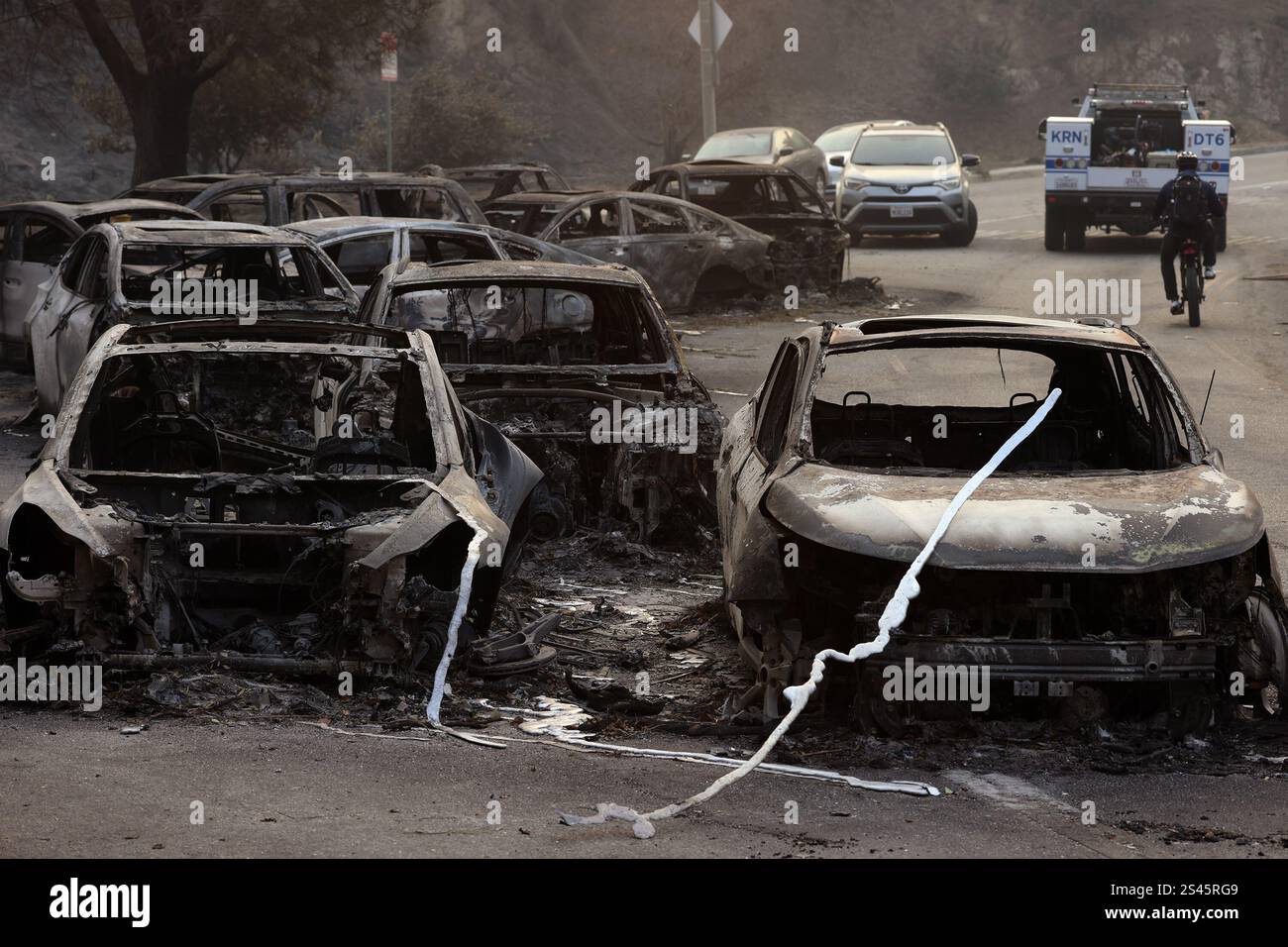 Los Angeles, California, USA. 10th Jan, 2025. A cyclist passes burned ...