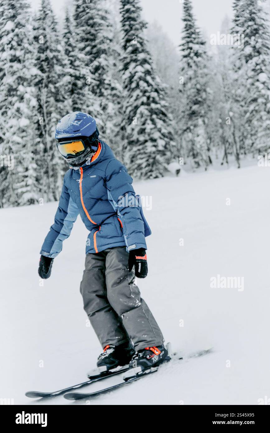 Snowboarder sliding down a snowy slope, rider relaxing at a ski resort ...