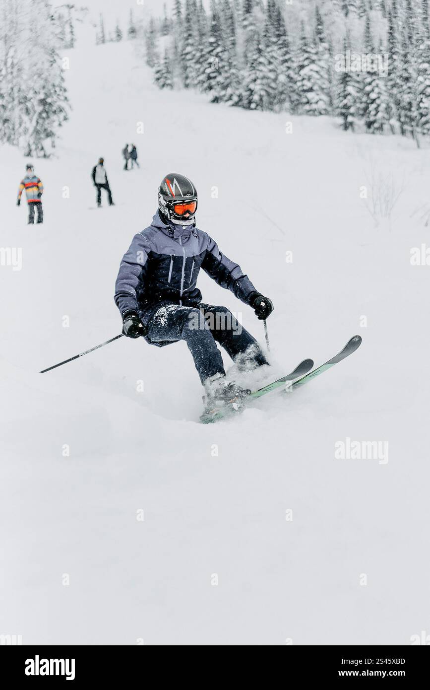 Snowboarder sliding down a snowy slope, rider relaxing at a ski resort ...