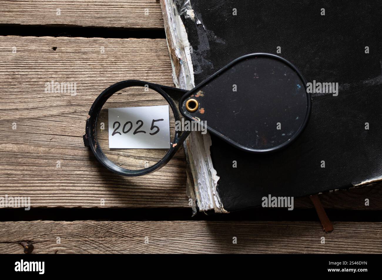 An old torn notebook and a magnifying glass and a card with the text ...