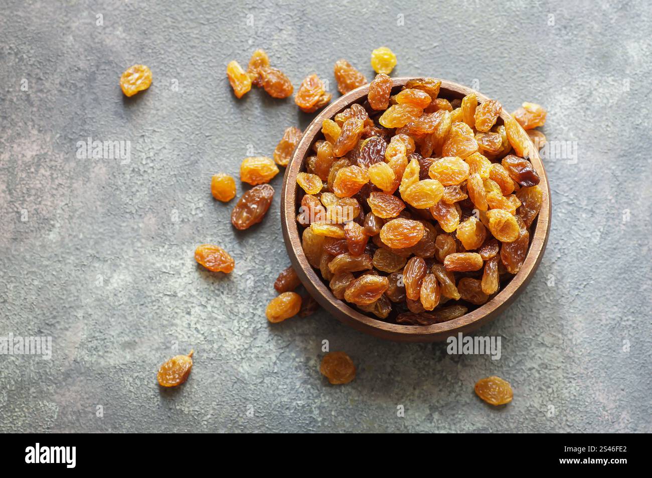 Dried grapes in wooden bowl or scoop on rustic background, healthy dry ...