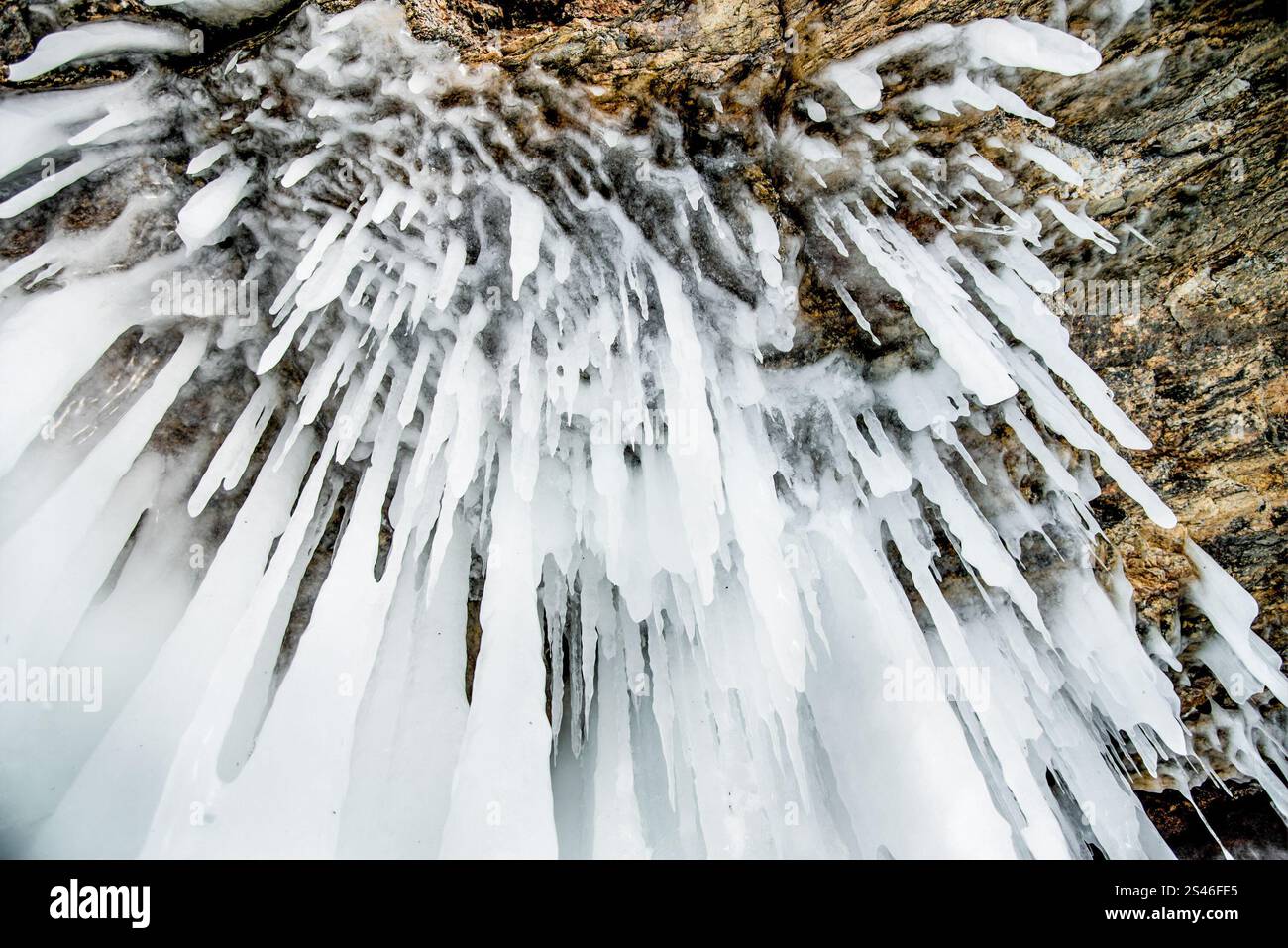 Ice icicles hanging on the stone surface of the cave, frozen water in ...