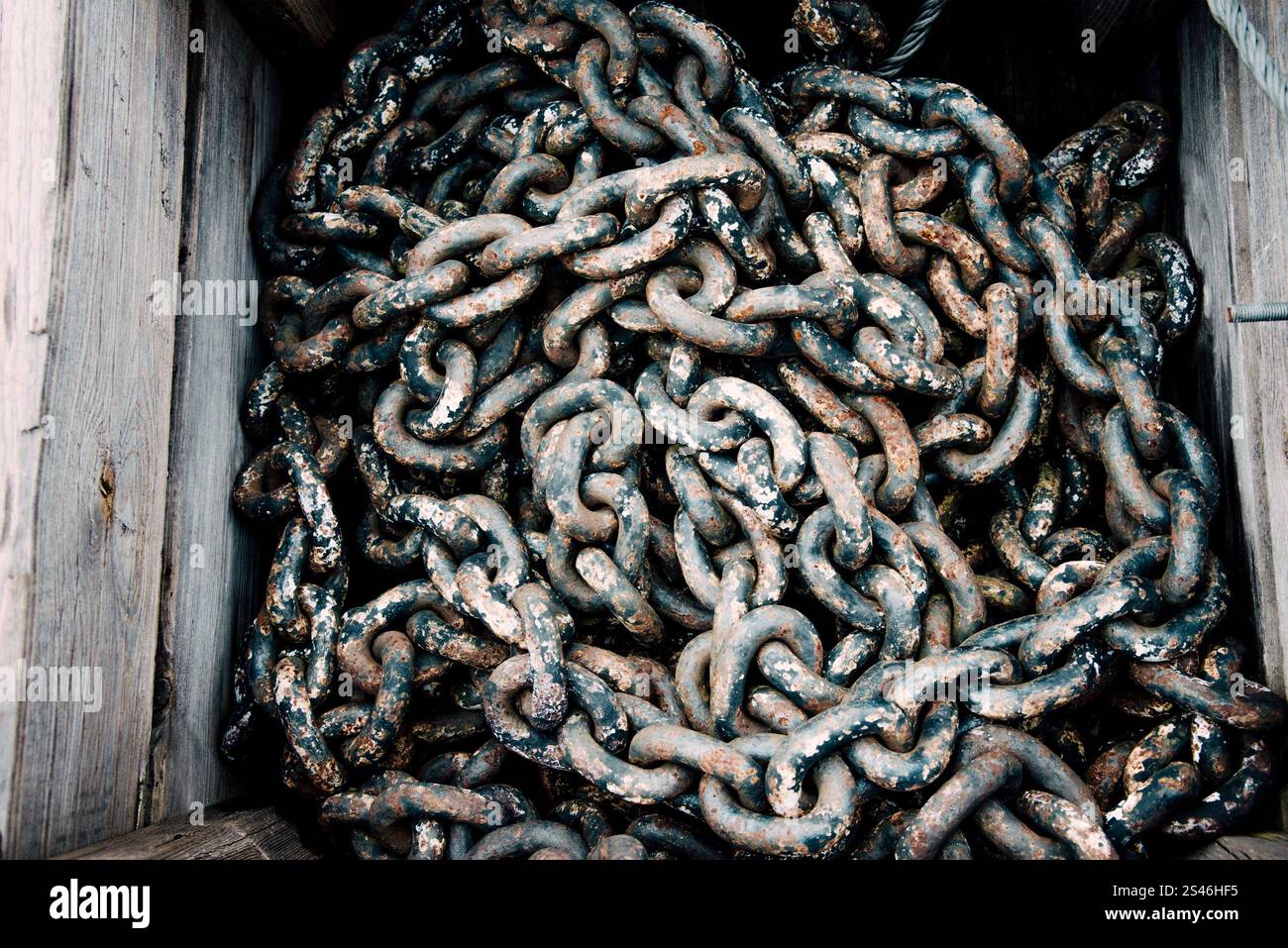 Large rusty metal chain from ship anchor lying in wooden box rebar ...