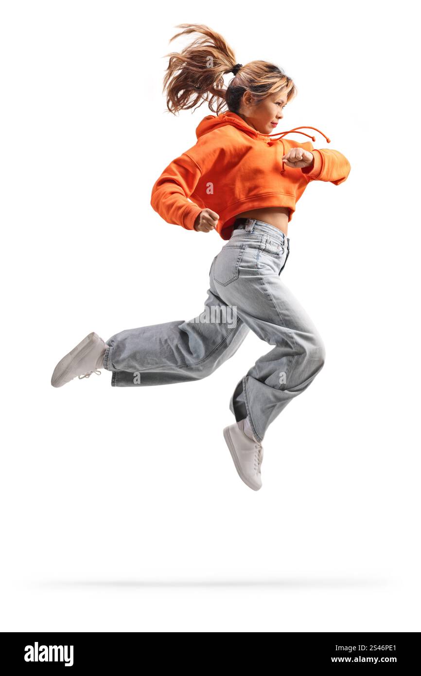 Full length profile shot of an asian female dancing and jumping ...