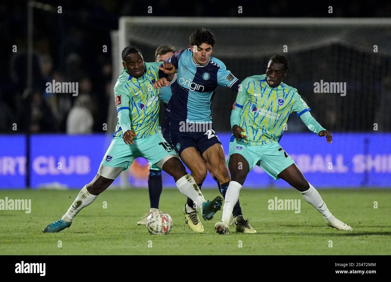 Wycombe Wanderers' Declan Skura (centre) battles with Portsmouth's ...