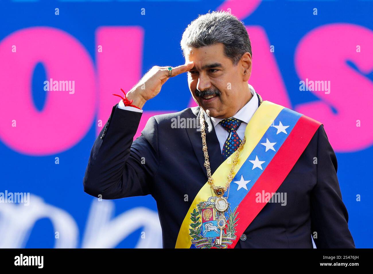 Venezuelan President Nicolas Maduro salutes supporters on his ...