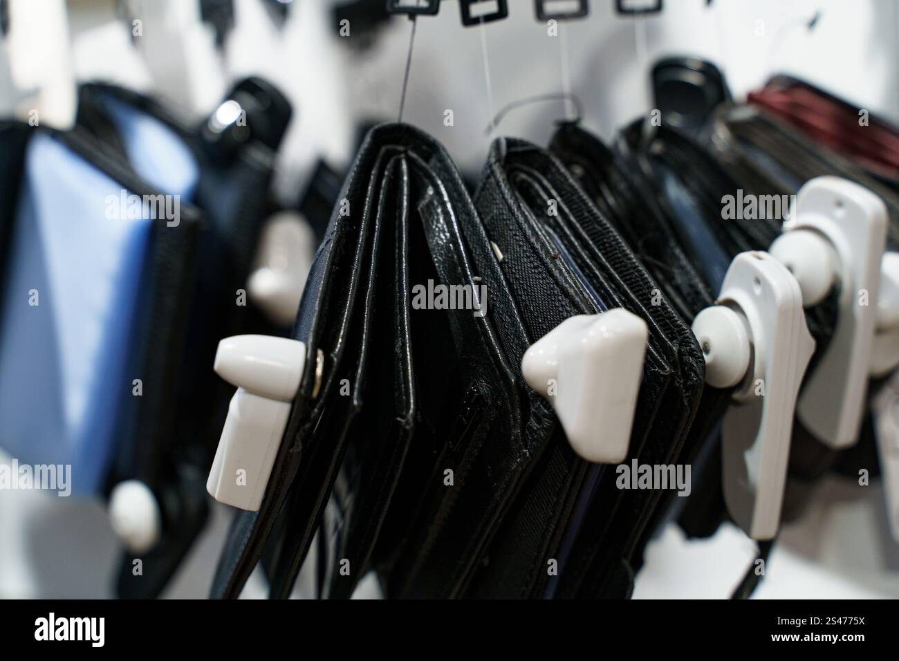 A variety of leather wallets hang neatly in a retail environment ...