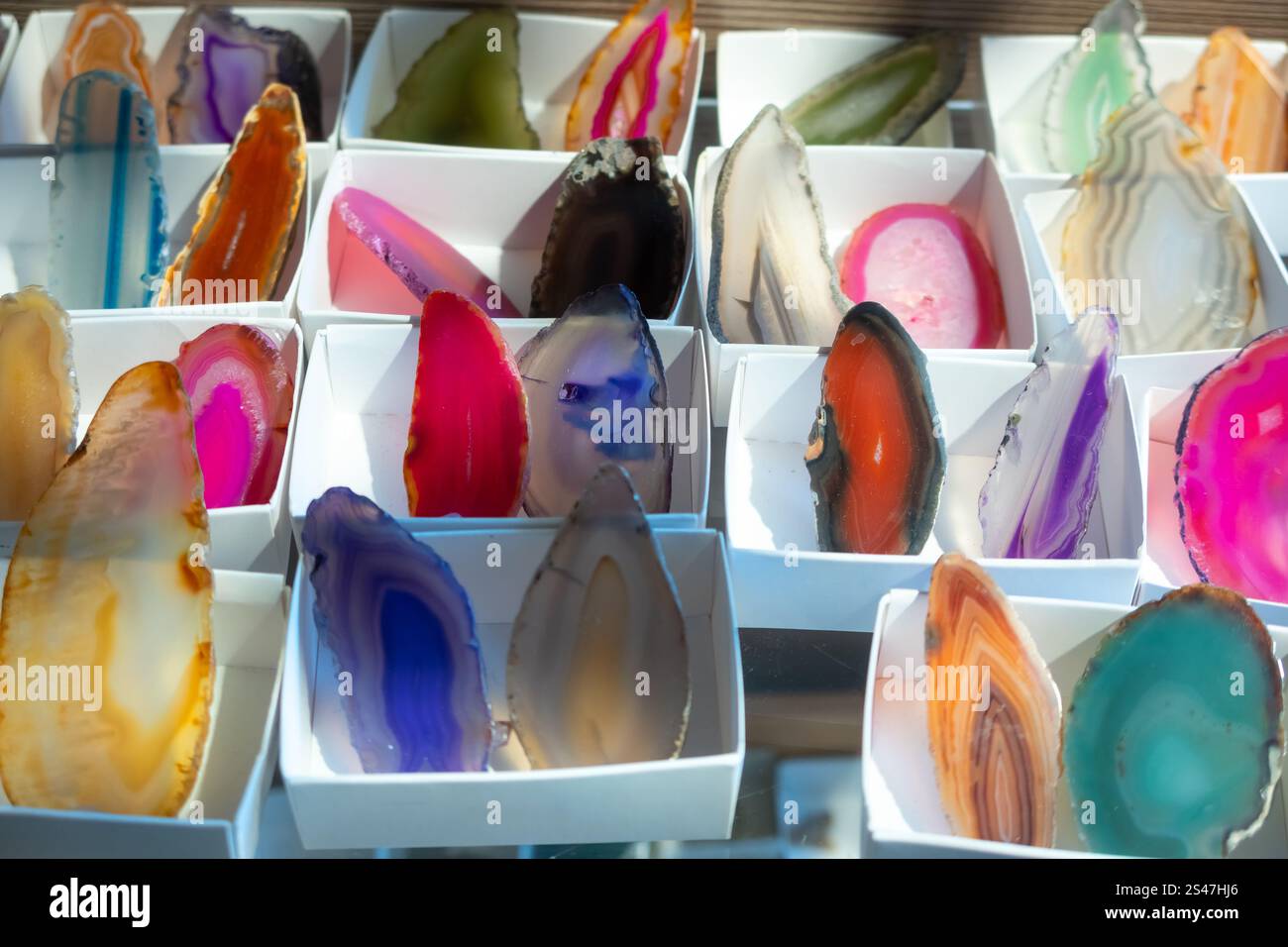 Close up view of many colorful Agate crystal slices in the boxes up for ...