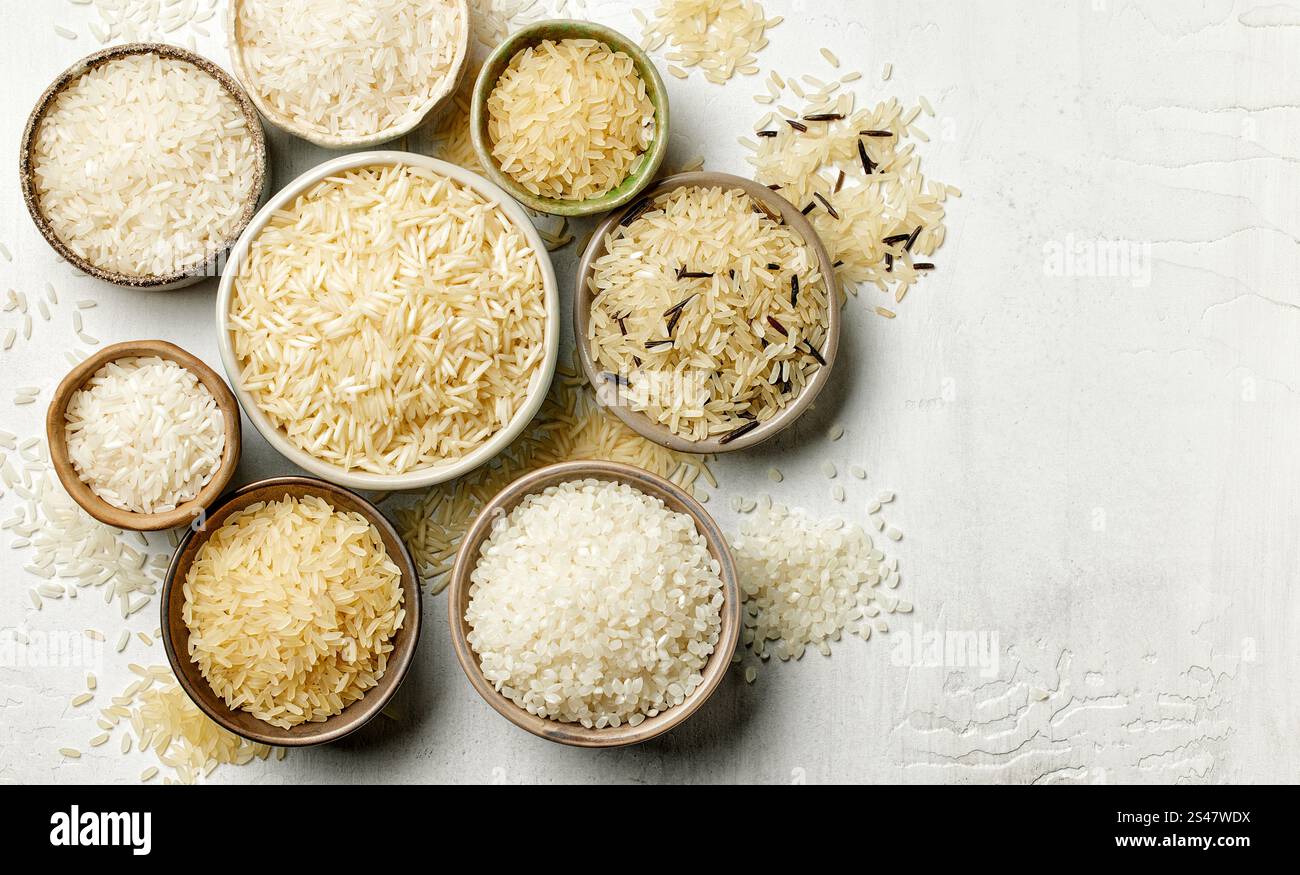 different types of rice on white kitchen table surface, top view Stock ...
