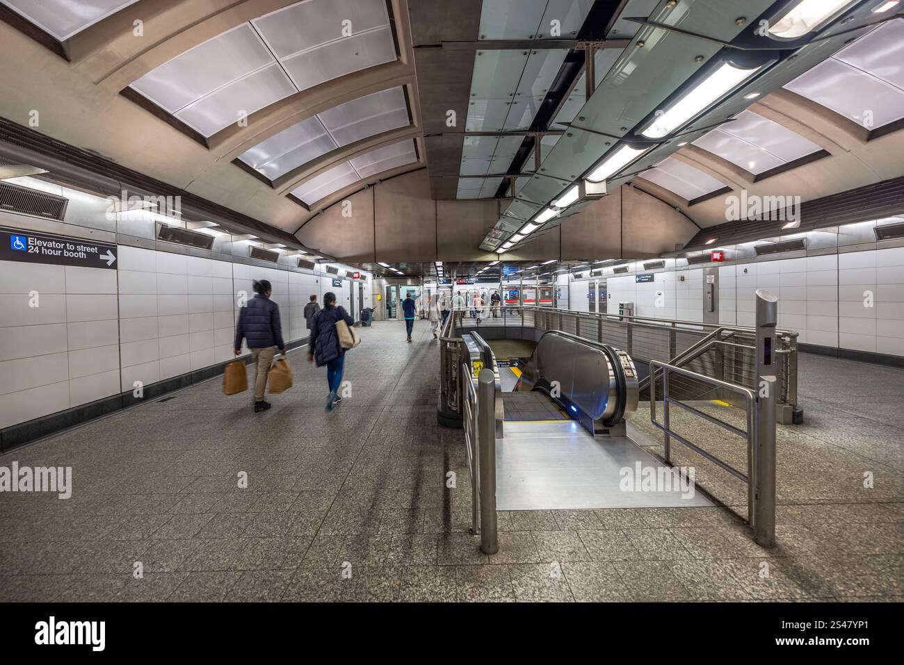Modern subway station interior with escalators, people walking, and ...