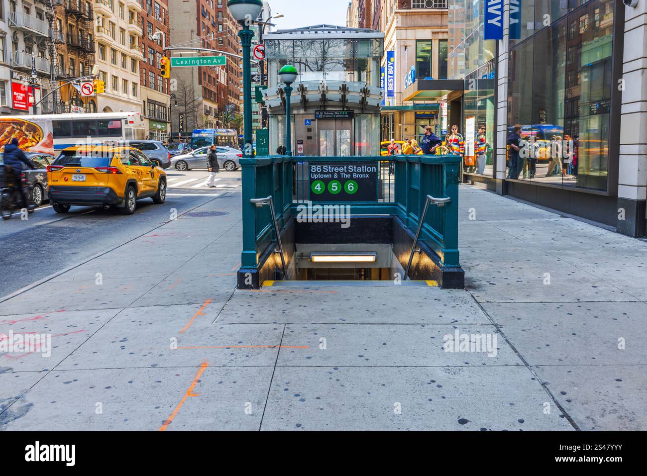 Entrance to 86th Street Station with green subway sign and busy urban ...
