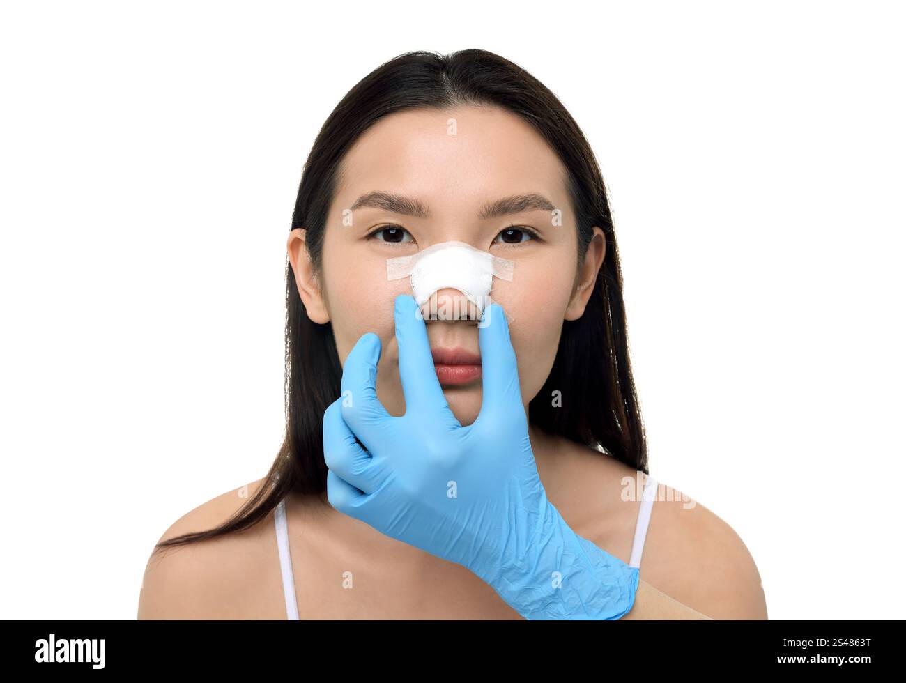 Doctor checking patient's nose after plastic surgery operation on white ...